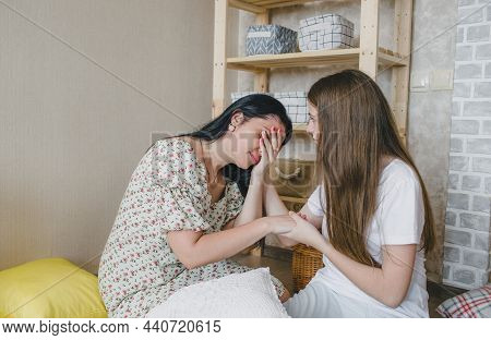 A Loving Daughter Comforts Her Sad Mom Sitting In A Room On The Floor ...