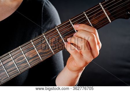 Seven-string Electric Guitar Made Of Dark Wood And Human Hands, Shot On ...