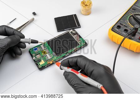 Master Of Radio Engineering Repairs A Part Of The Mobile Phone, Making ...