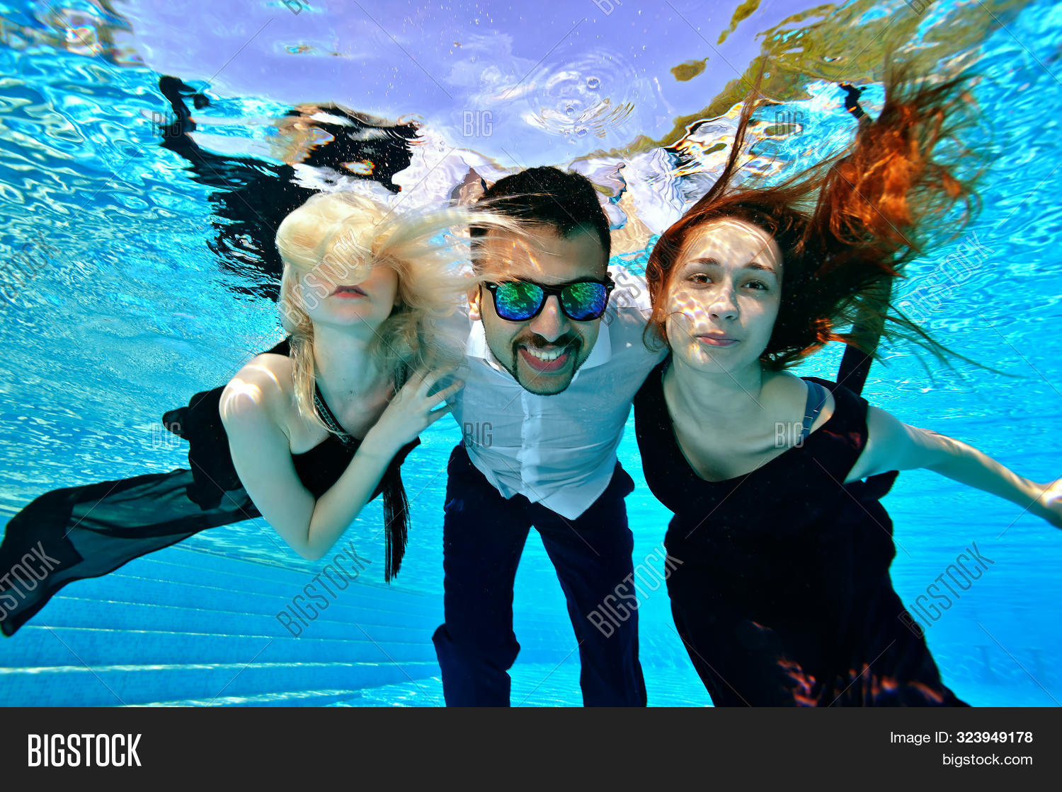People Swimming In A Pool Underwater