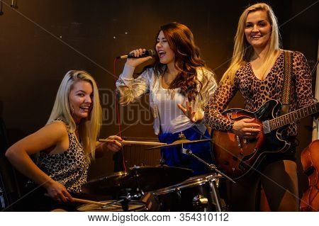 Woman Singing While Rest Of The Band Playing Instruments, Performing On ...