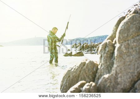 Male hunter getting ready for hunting wearing camouflage weatsuit with ...