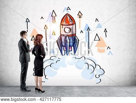 Two Thoughtful Business Partners Standing In Front Of Concrete Wall ...