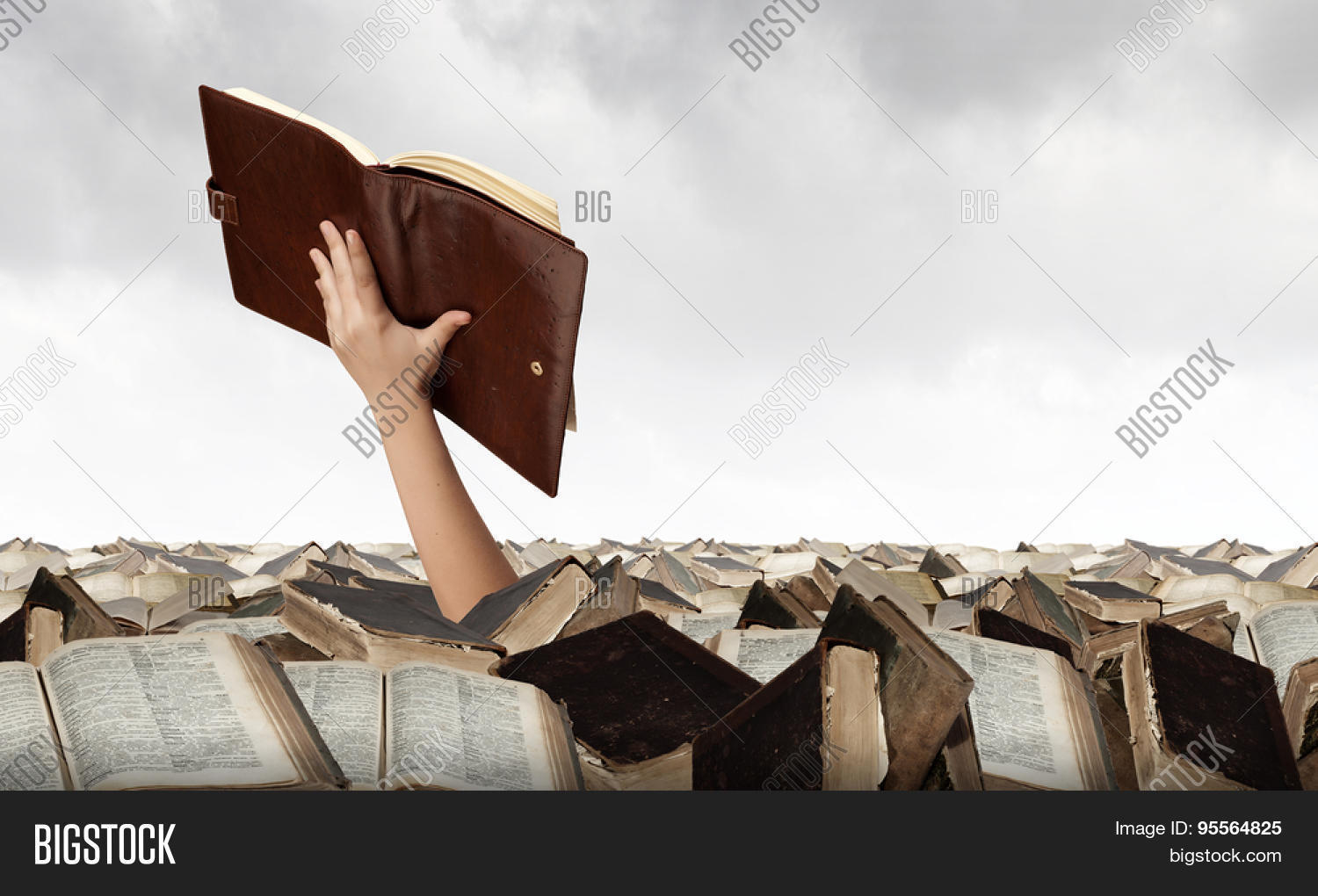 Hand with book reaching out from pile of old books Stock Photo & Stock ...