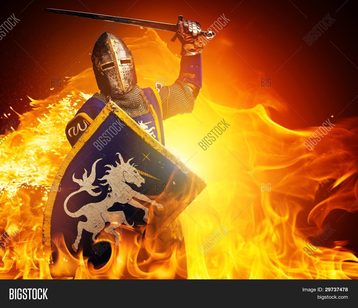Medieval knight in attack position on fire background. Stock Photo ...